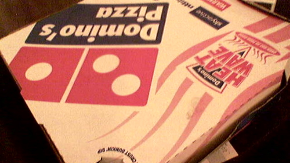A man throws his Domino's pizza box on the ground before eating it, and ...