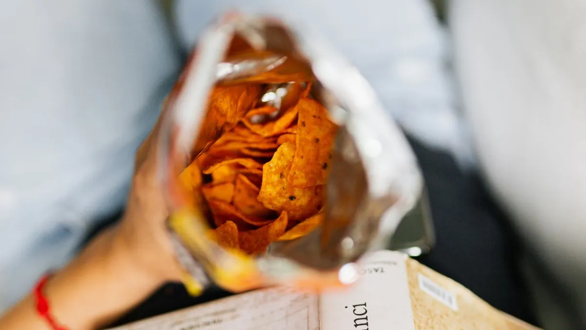 Woman opens a bag of chips, then dips it in something that prompts the ...
